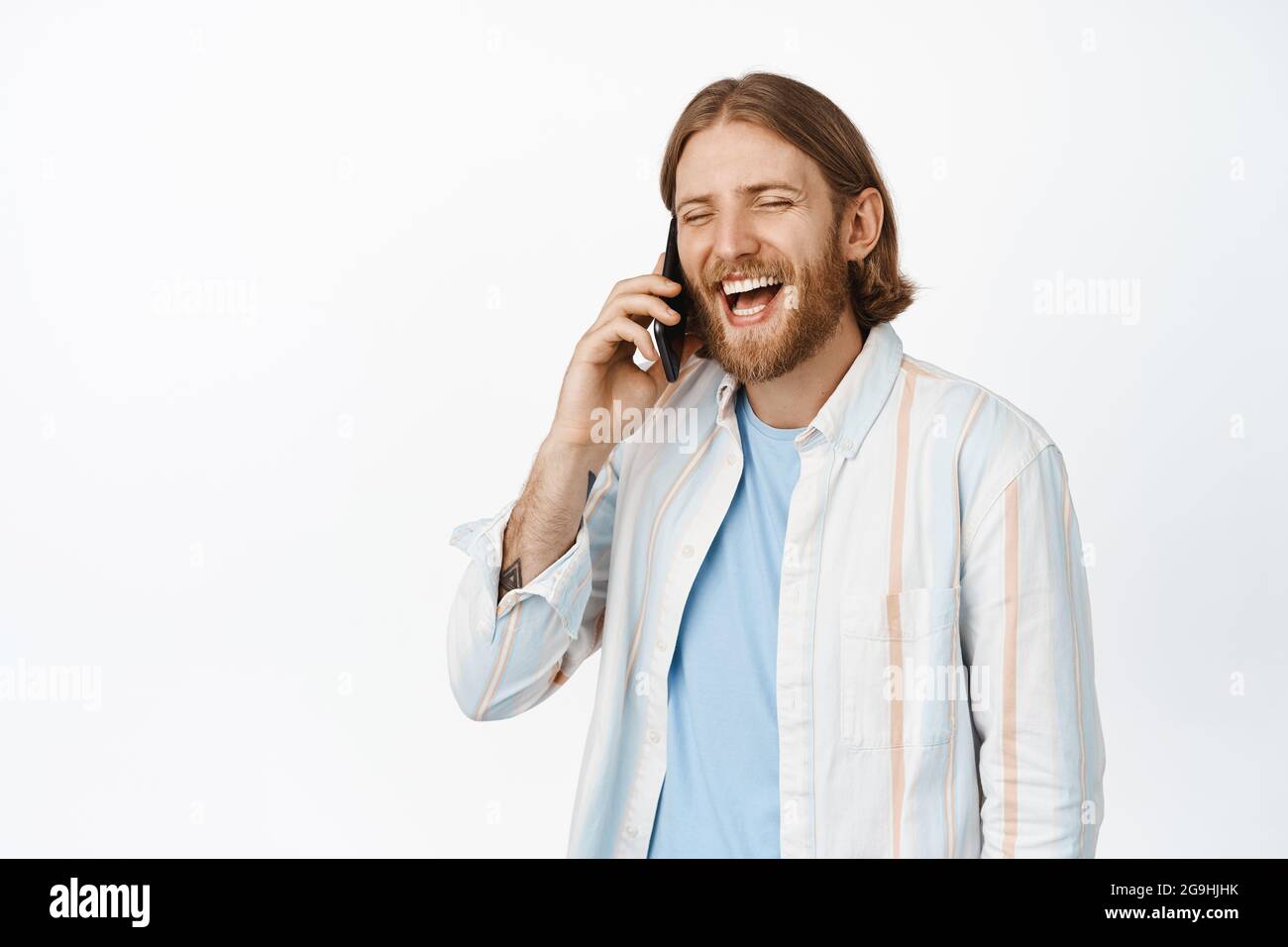 Portrait of handsome happy guy talking on cellphone, laughing and ...