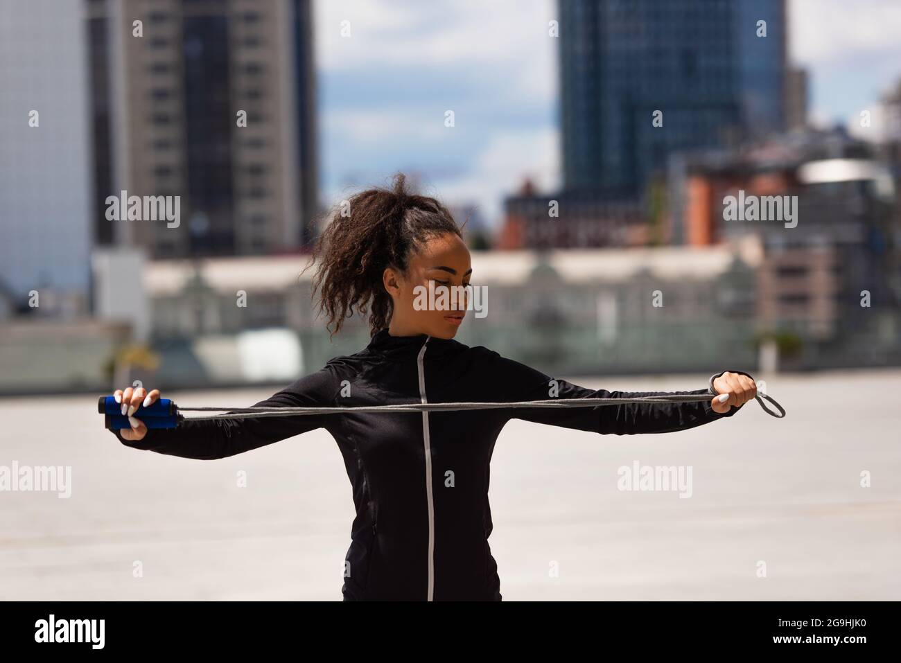 African american sportswoman holding jump rope outdoors Stock Photo - Alamy