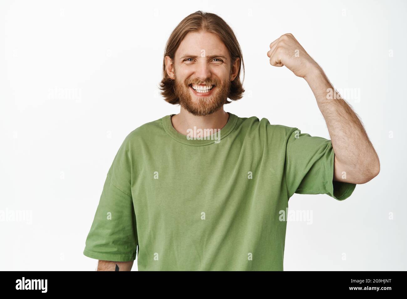 Portrait of excited blond man chanting, winning something, raising his ...