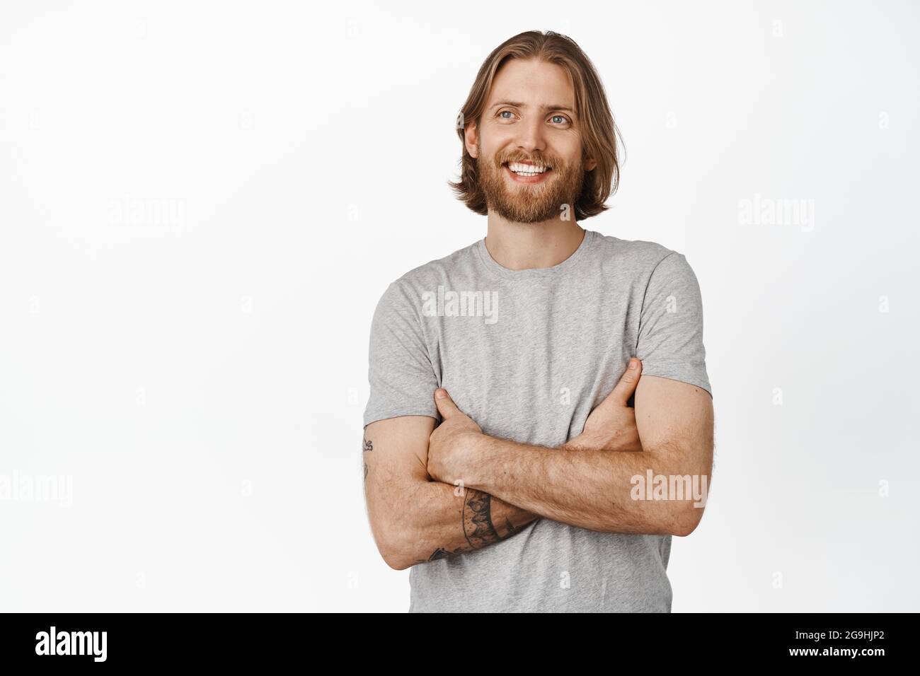 Portrait of handsome caucasian man with blond hair, cross arms on chest ...