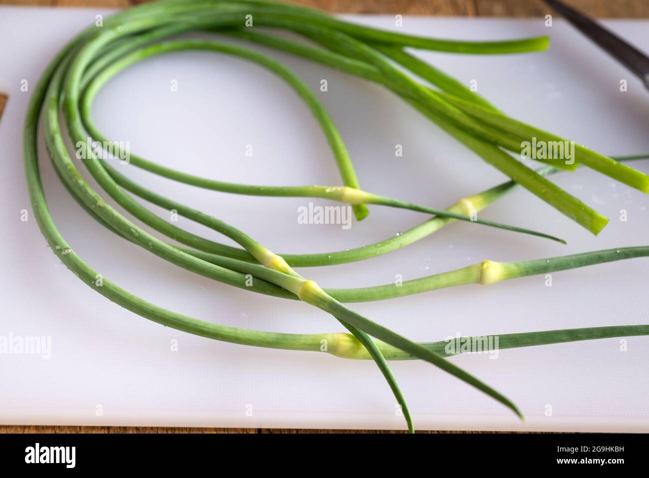 Garlic scapes being prepared in the kitchen Stock Photo - Alamy