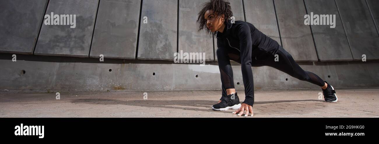 Young african american runner standing in starting pose on urban street ...