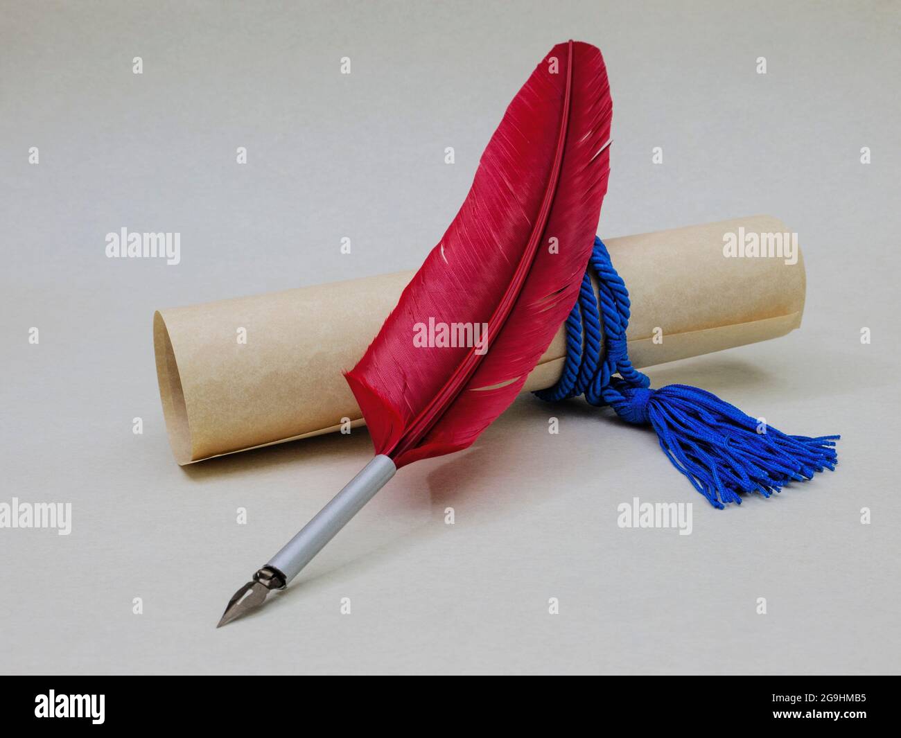 Ancient pen with a red feather resting on a parchment closed by a blue ...