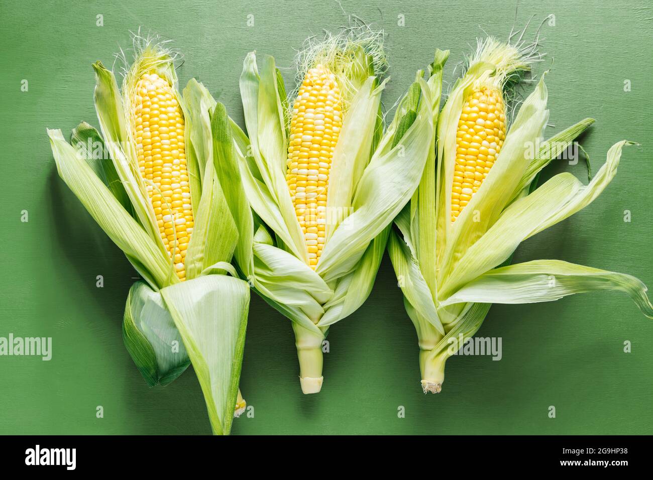 Fresh corn on the cob with green leaves Stock Photo - Alamy