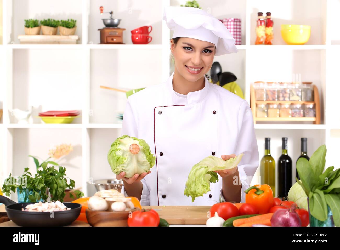 Young woman chef cooking in kitchen Stock Photo - Alamy