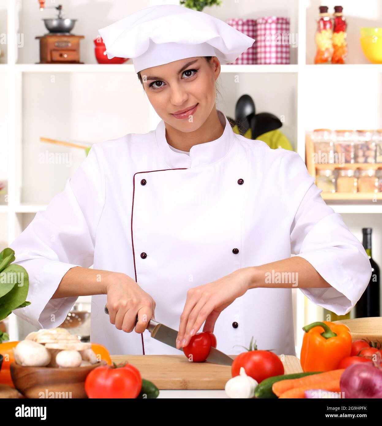 Young woman chef cooking in kitchen Stock Photo - Alamy