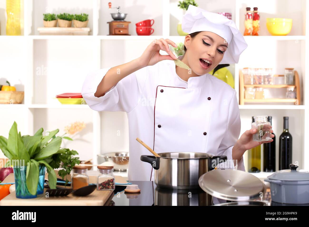 Young woman chef cooking in kitchen Stock Photo - Alamy