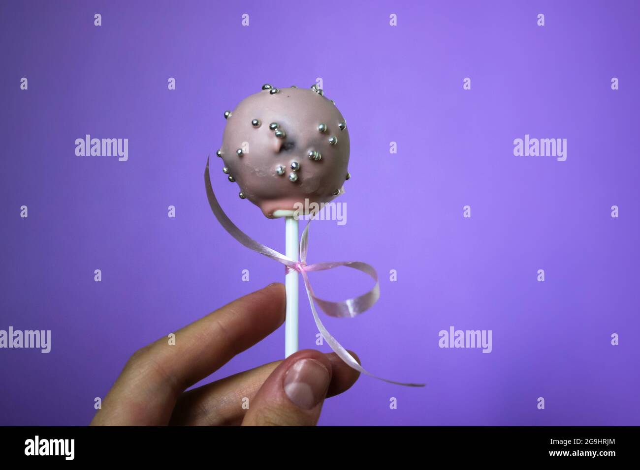 Pink chocolate cake pops with strawberry flavour on a purple background ...