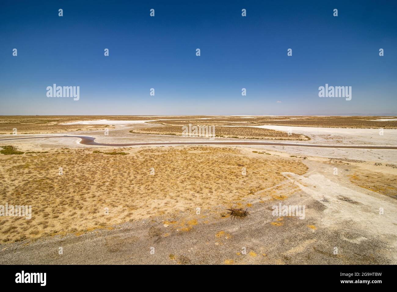 Salty lake coast. The shore is covered with salt deposits on a white ...