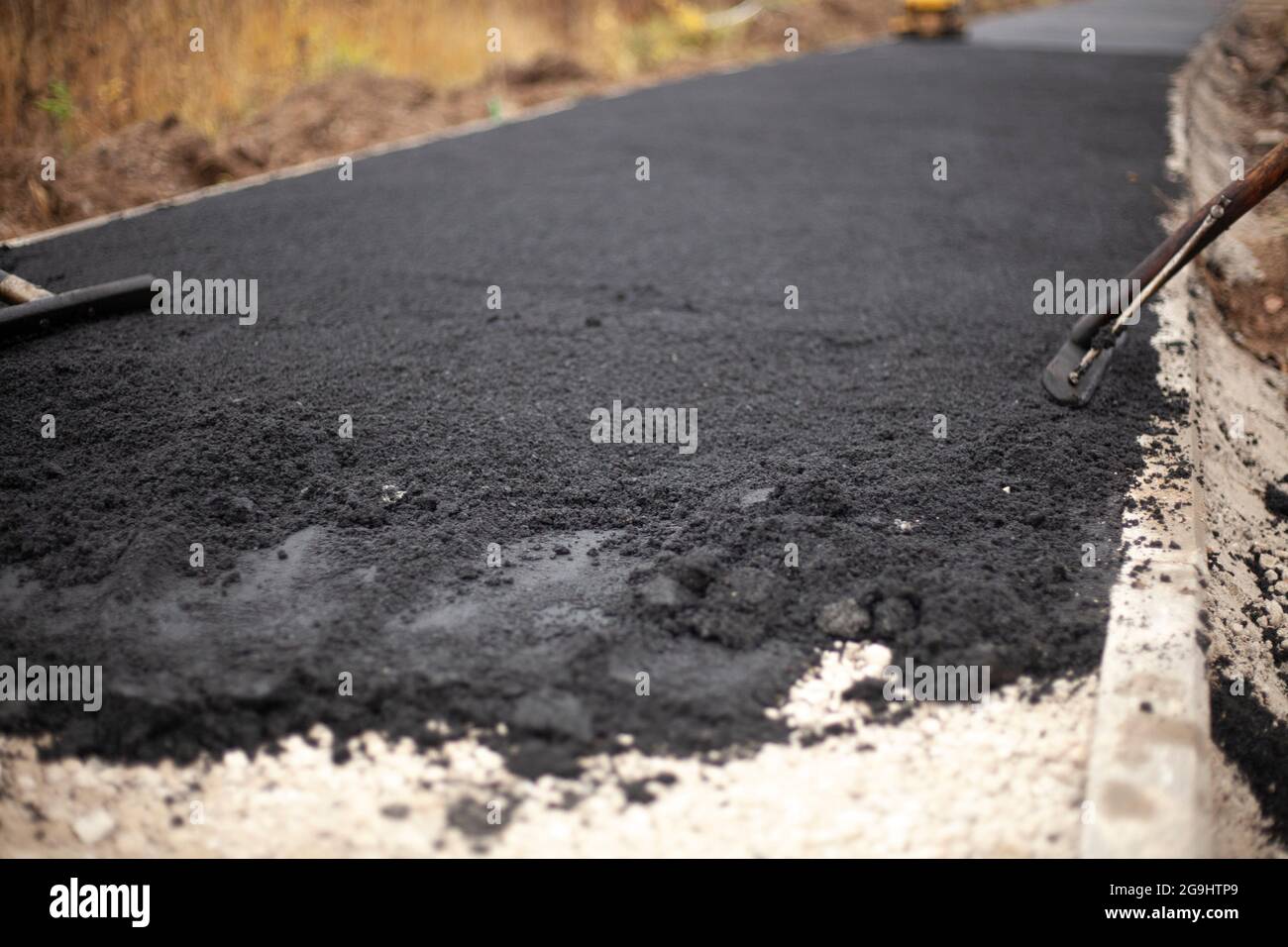 Asphalt laying. Repair of the footpath. Smoothing hot pavement Stock ...