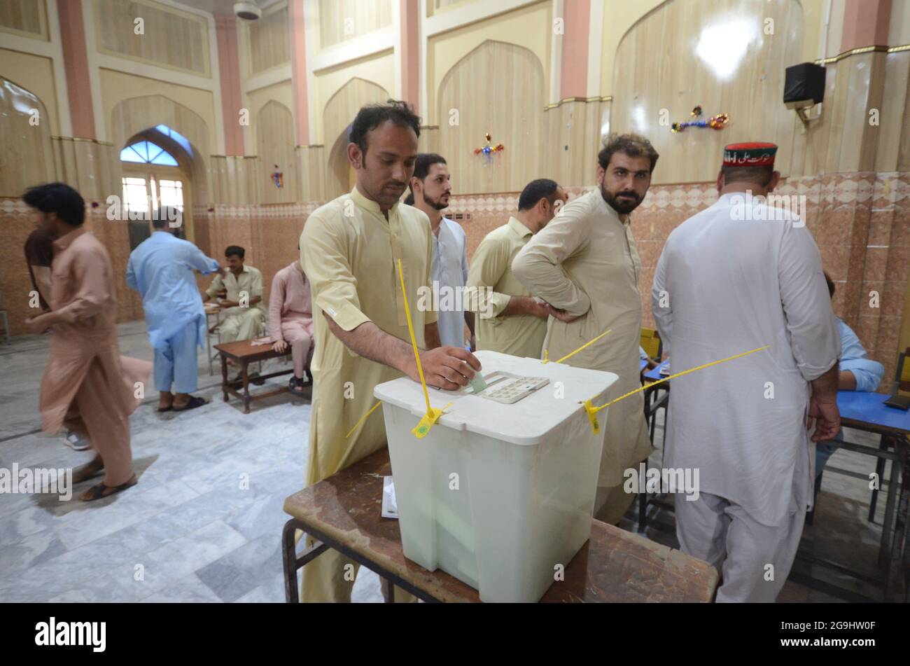 Peshawar, Pakistan. 25th July, 2021. A man casting the ballot for Azad ...