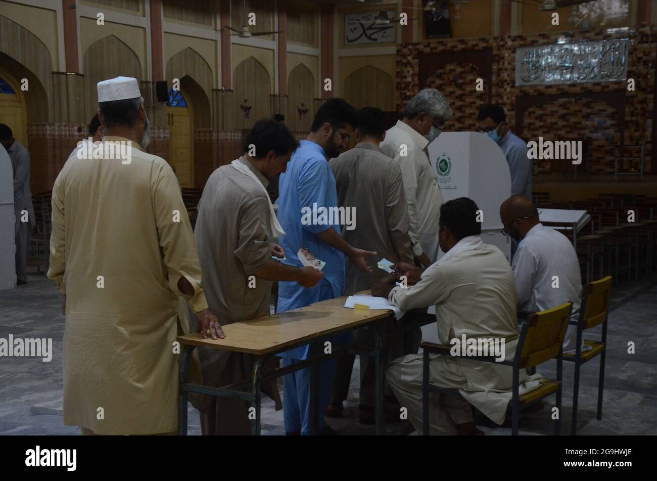 Peshawar, Pakistan. 25th July, 2021. A man casting the ballot for Azad ...