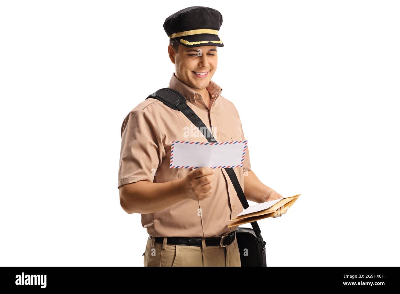 Young smiling mailman in a uniform looking at a letter isolated on ...