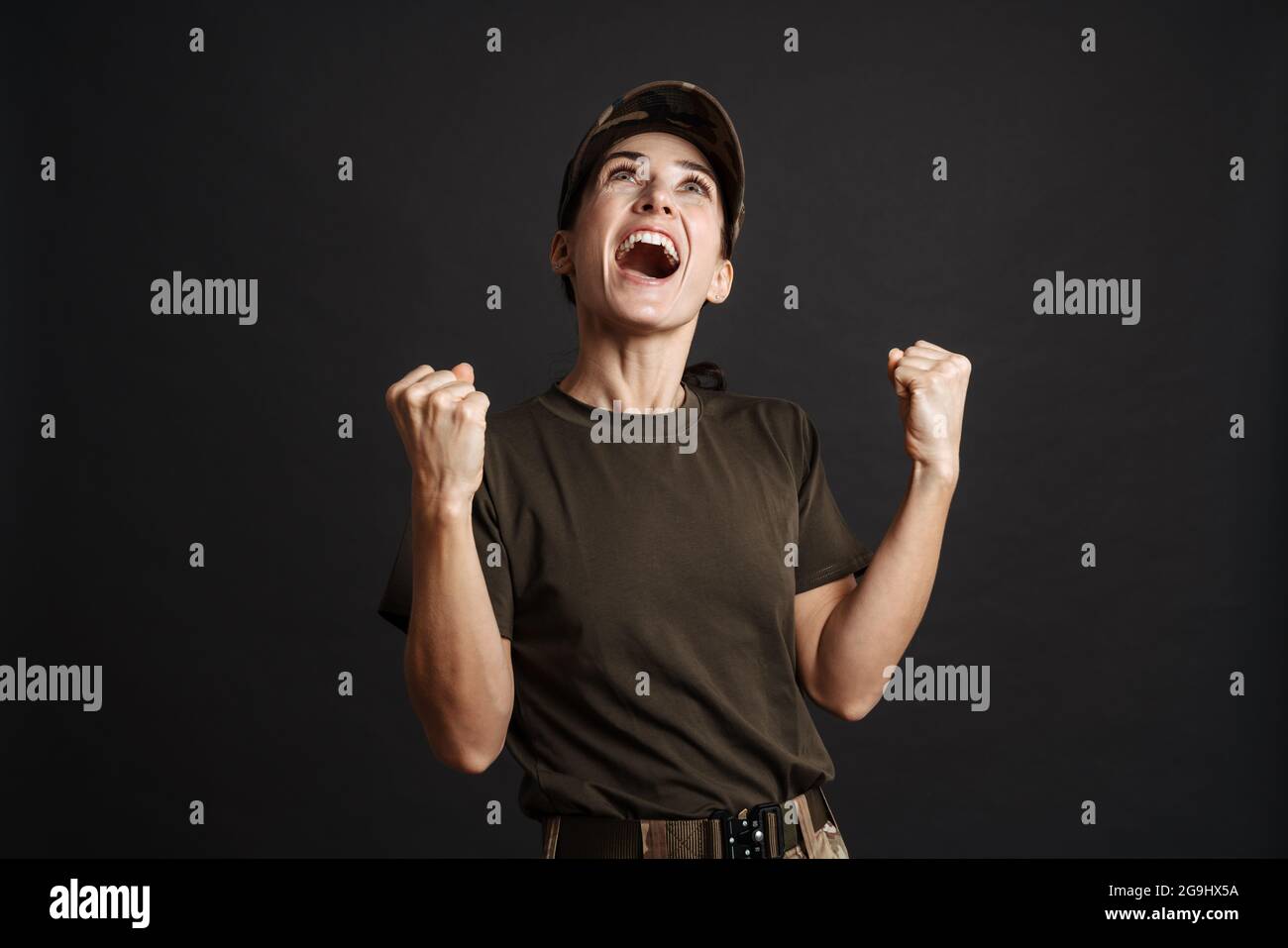 Caucasian female soldier rejoicing her success and victory clenching ...