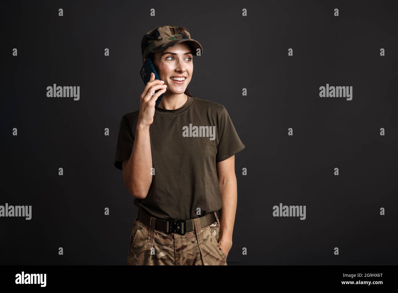 Happy beautiful soldier woman smiling while talking on mobile phone ...