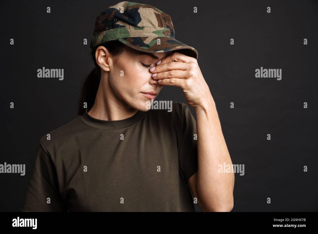 Upset worried young military woman standing isolated over black ...