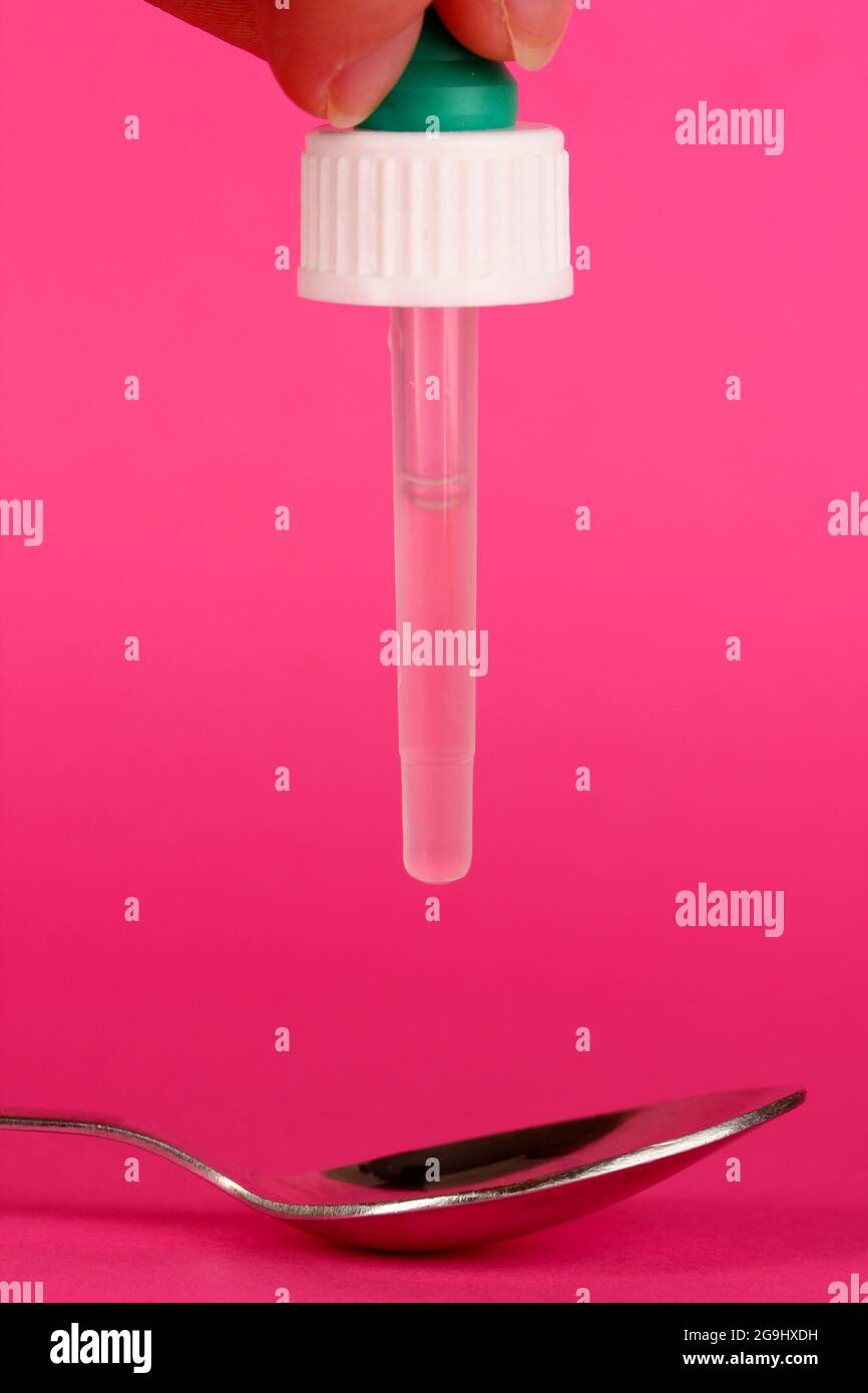 Medical droplet in spoon on pink background Stock Photo - Alamy