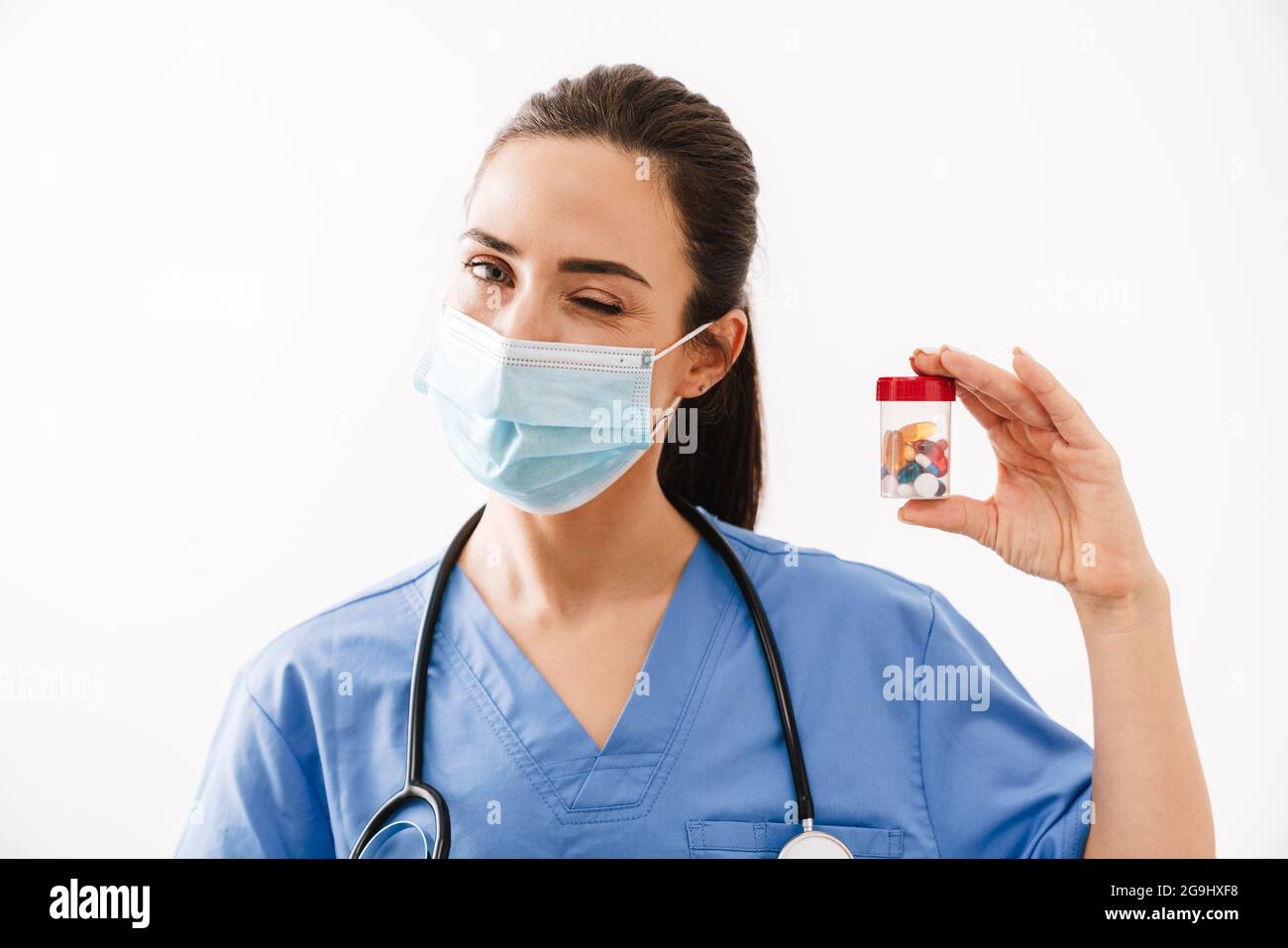 Confident young woman doctir showing bottle with pills isolated over ...
