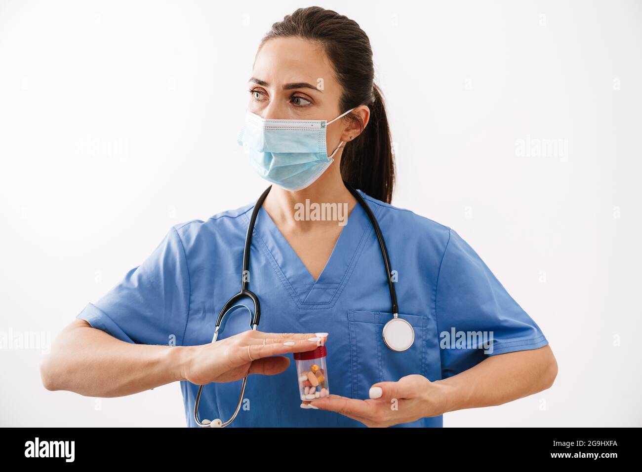 Confident young woman doctir showing bottle with pills isolated over ...