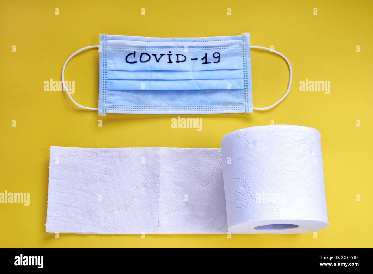 Medical mask with inscription covid-19 and roll of unwound toilet paper ...