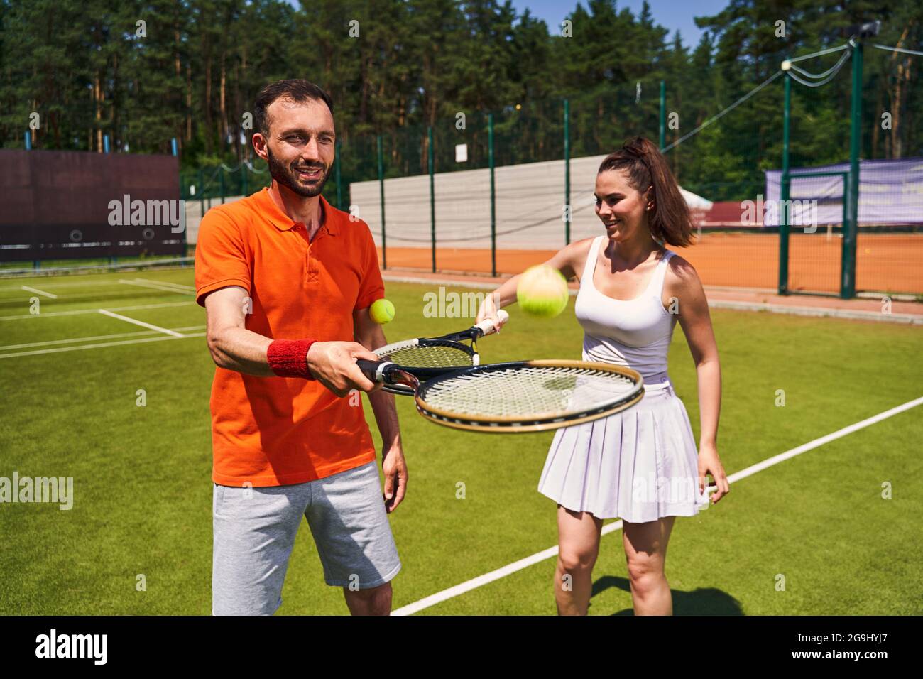 Two focused tennis players practicing their serve technique Stock Photo ...