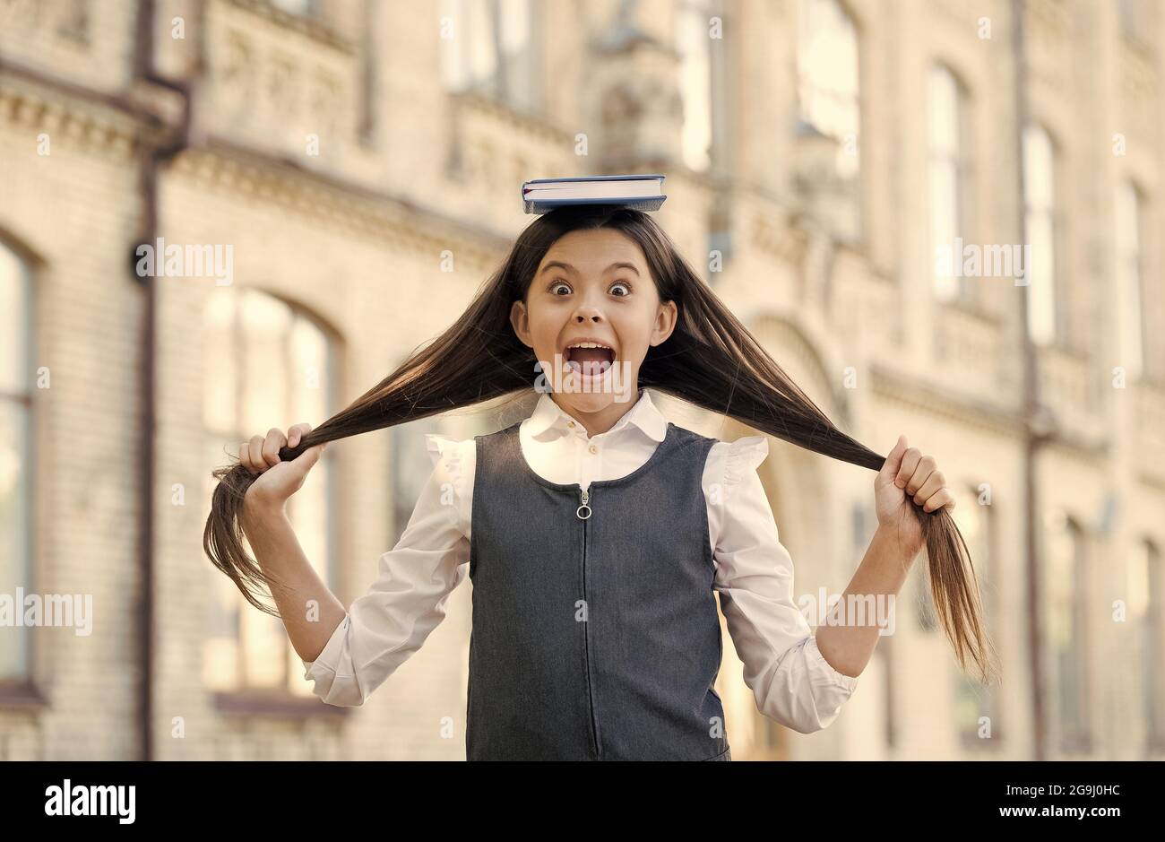 You are not alone with book. Happy kid hold book on head outdoors ...