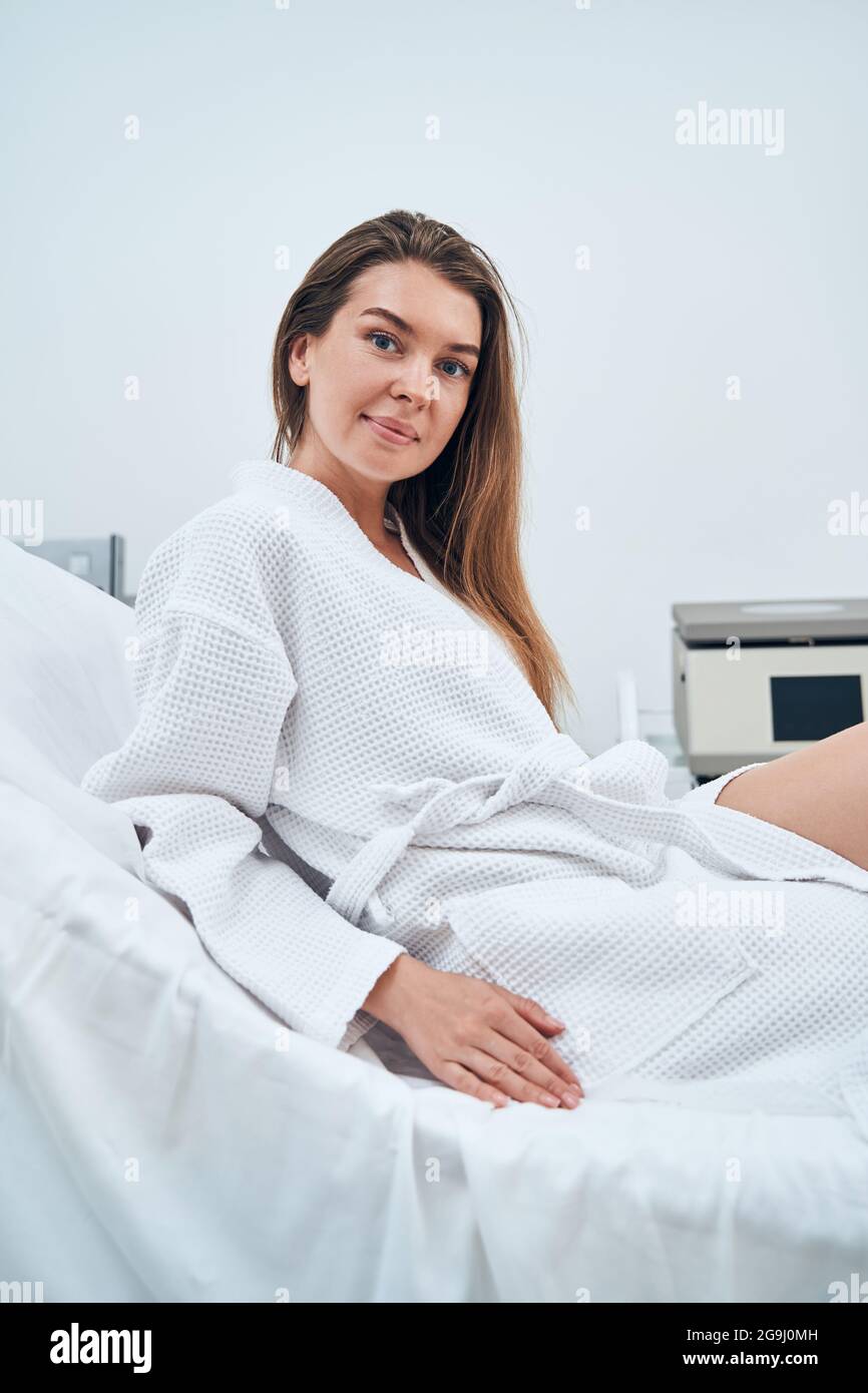 Positive delighted female patient sitting on couch Stock Photo - Alamy