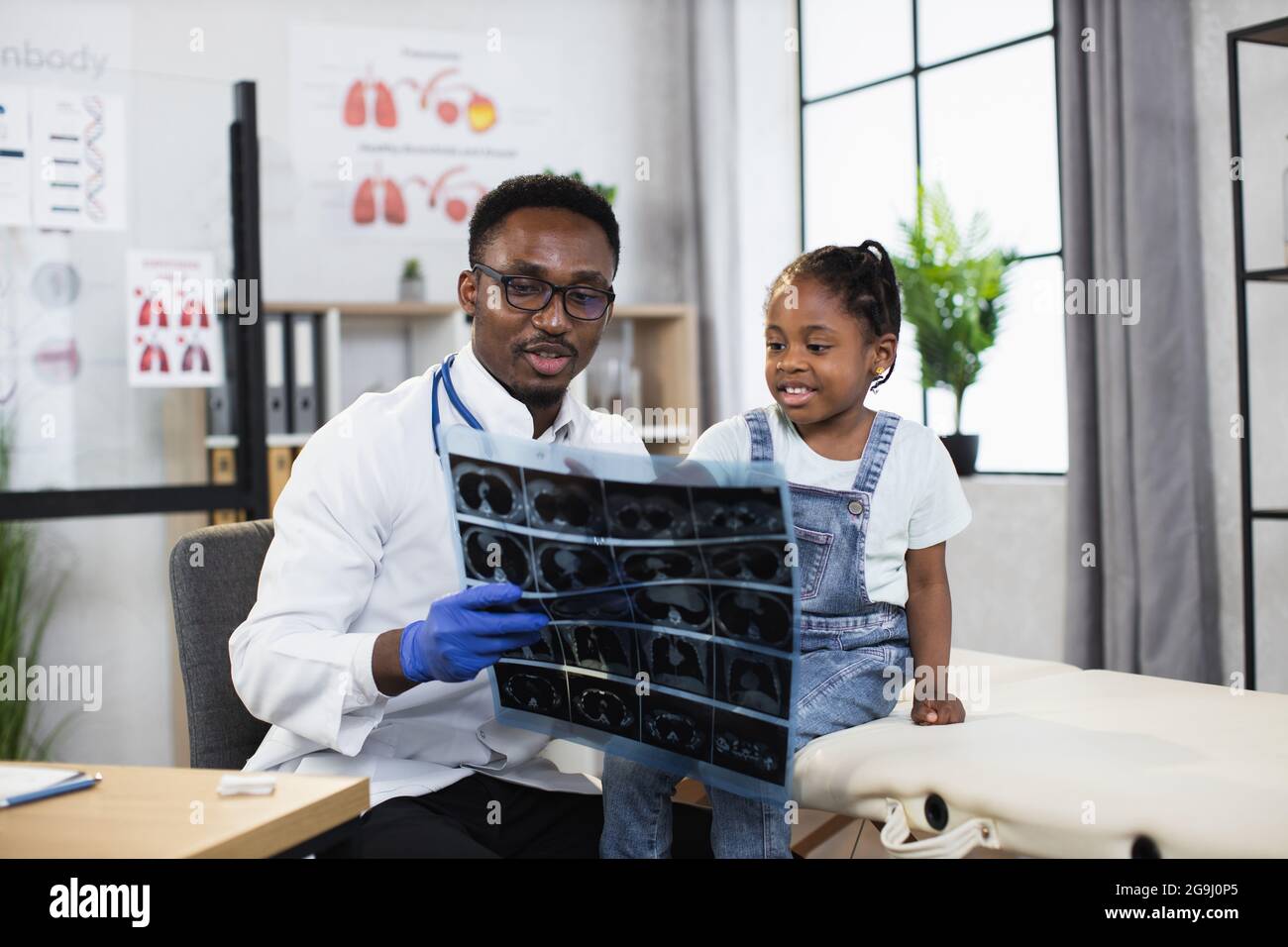 Handsome friendly smiling black-skinned male doctor pediatrician ...
