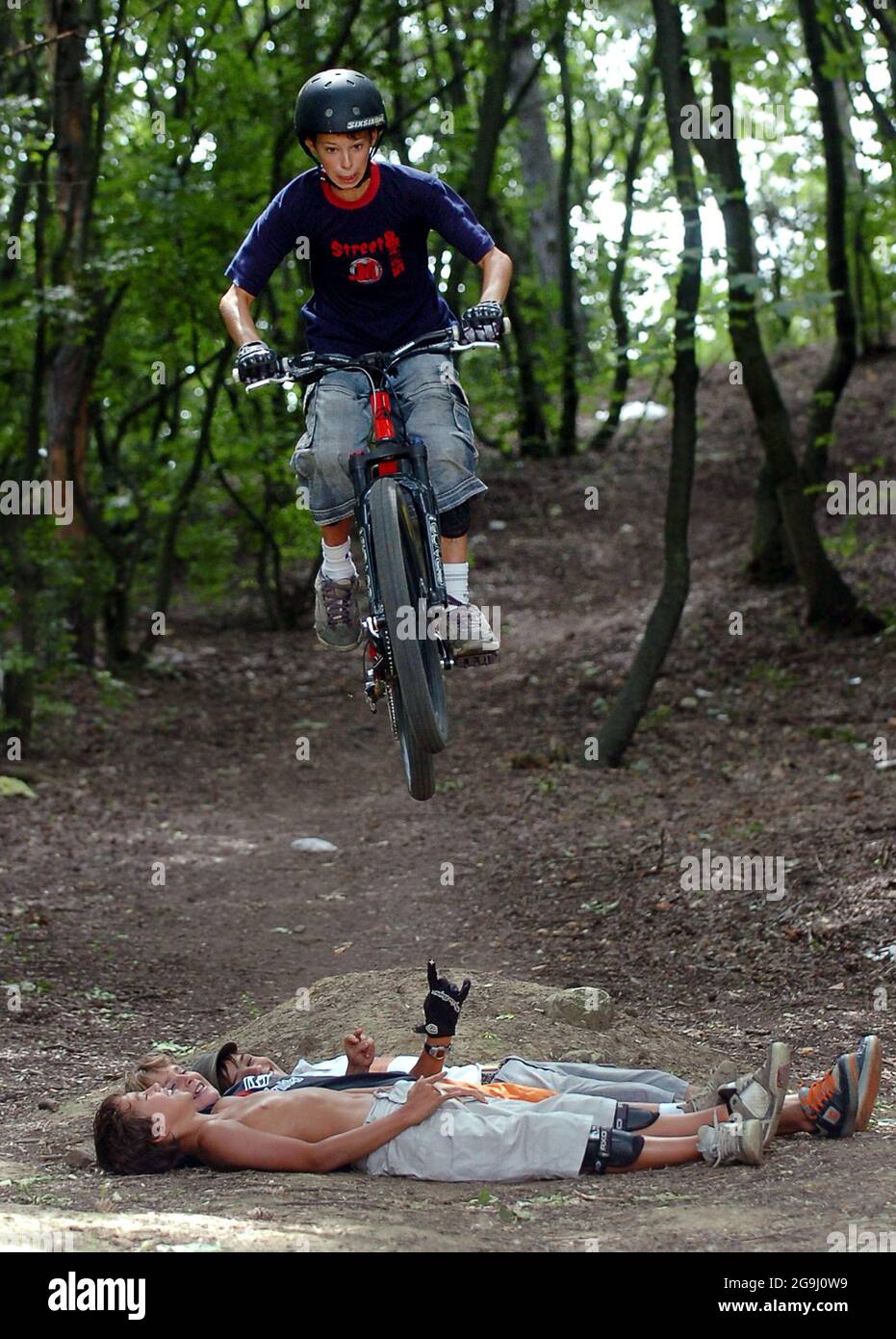 Young boys doing dare devil bicycle stunts in woodland near Budapest in ...
