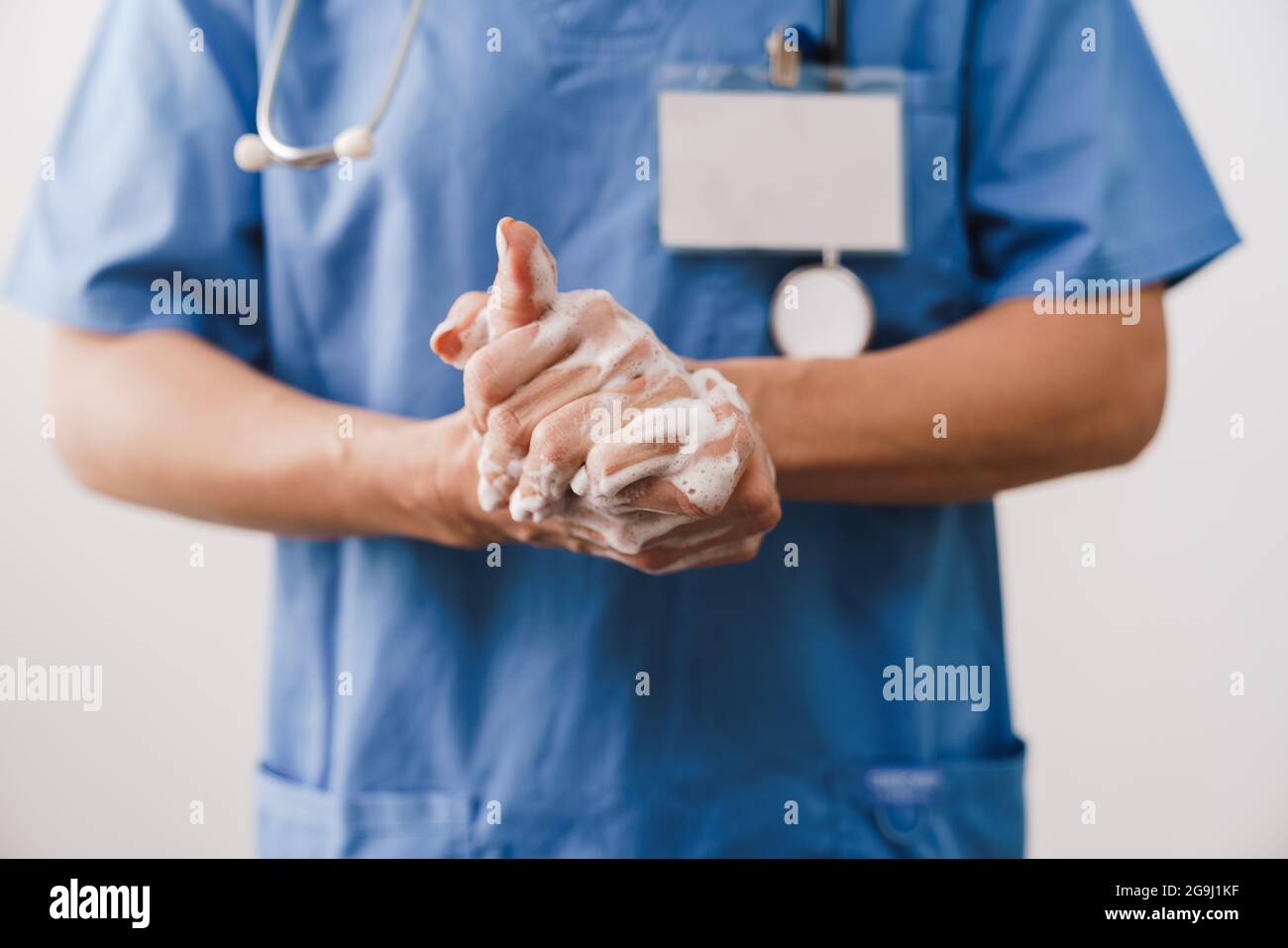 Close up of a female doctor washing her hands with soap isolated over ...