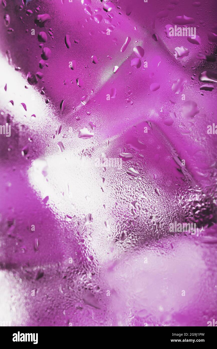 Ice cubes in a misted glass with drops of ice water close-up macro. Refreshing and chilling ...