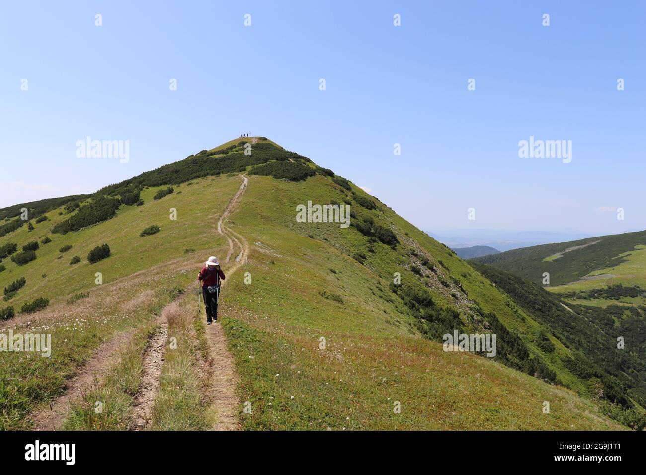 A mountaineer on a hiking trail below the top of the Nadkrstac ...