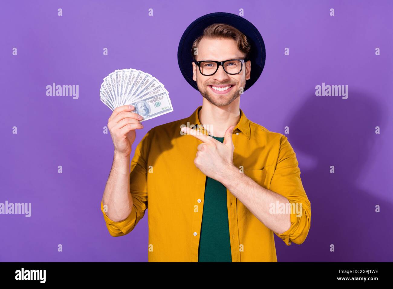 Portrait of attractive cheerful guy holding demonstrating fan cash ...