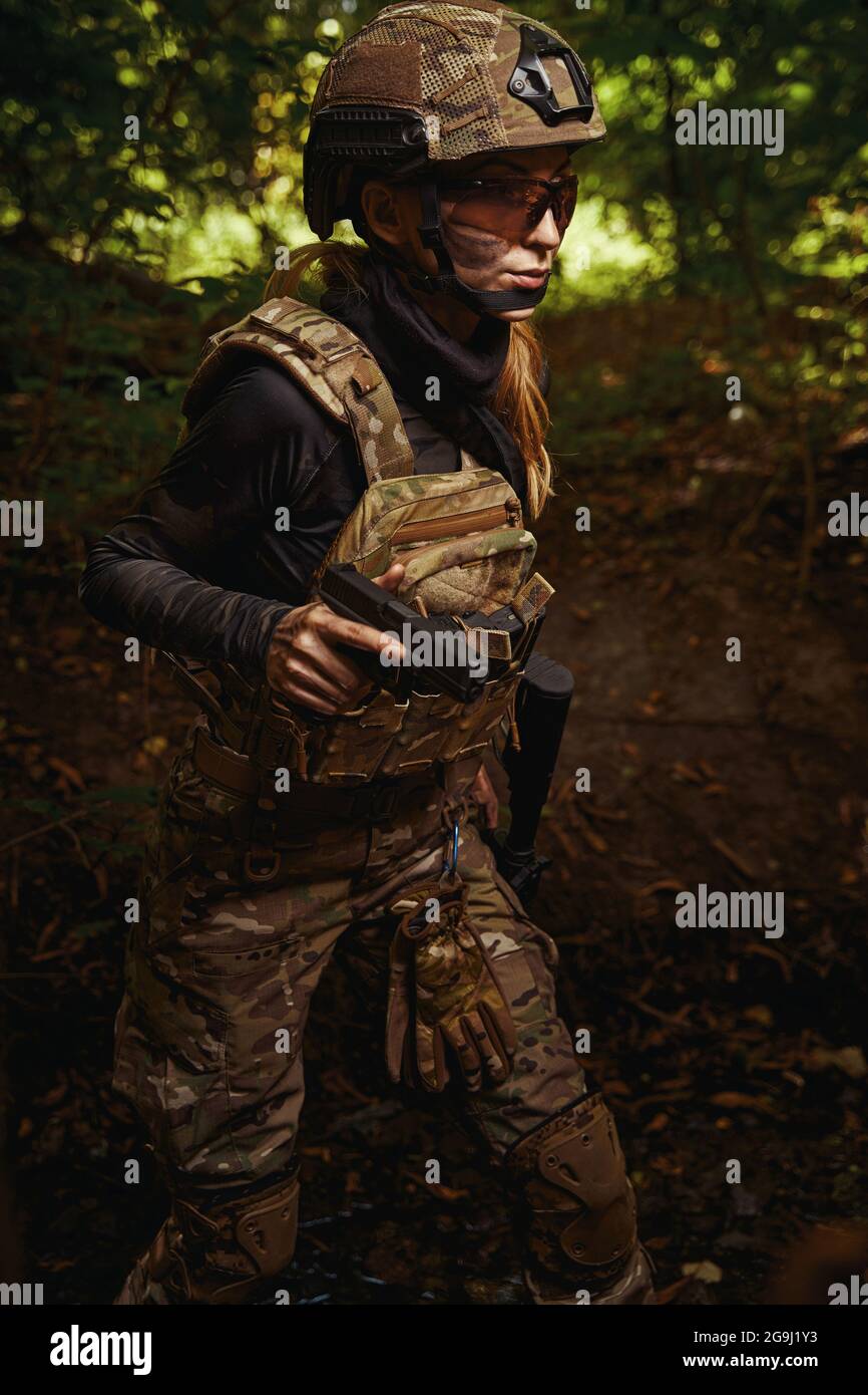 Female person aiming with weapon at target Stock Photo - Alamy