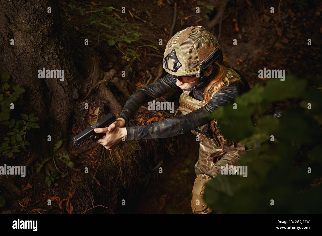 Female person aiming with gun at target Stock Photo - Alamy
