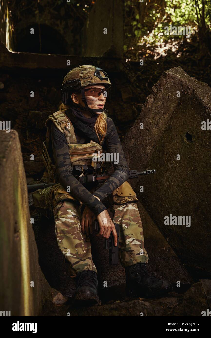 Serious female person sitting on concrete slab Stock Photo - Alamy