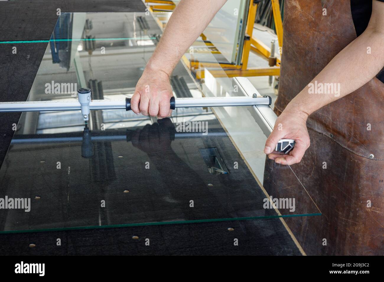 The glazier cuts a large sheet of glass. Glass workshop, Specialist ...
