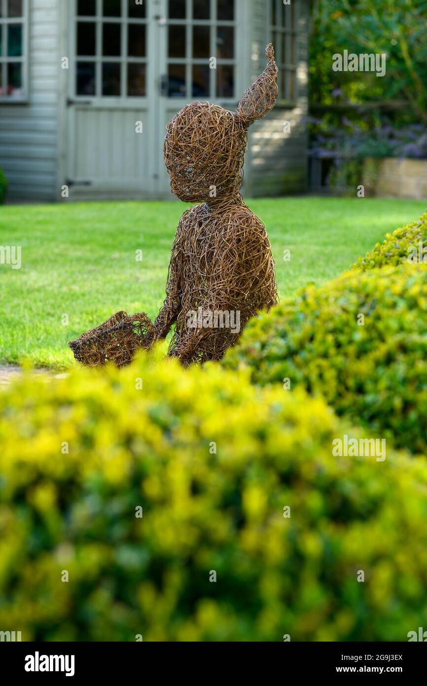 Willow sculpture art of girl (ornamental feature) in landscaped private ...