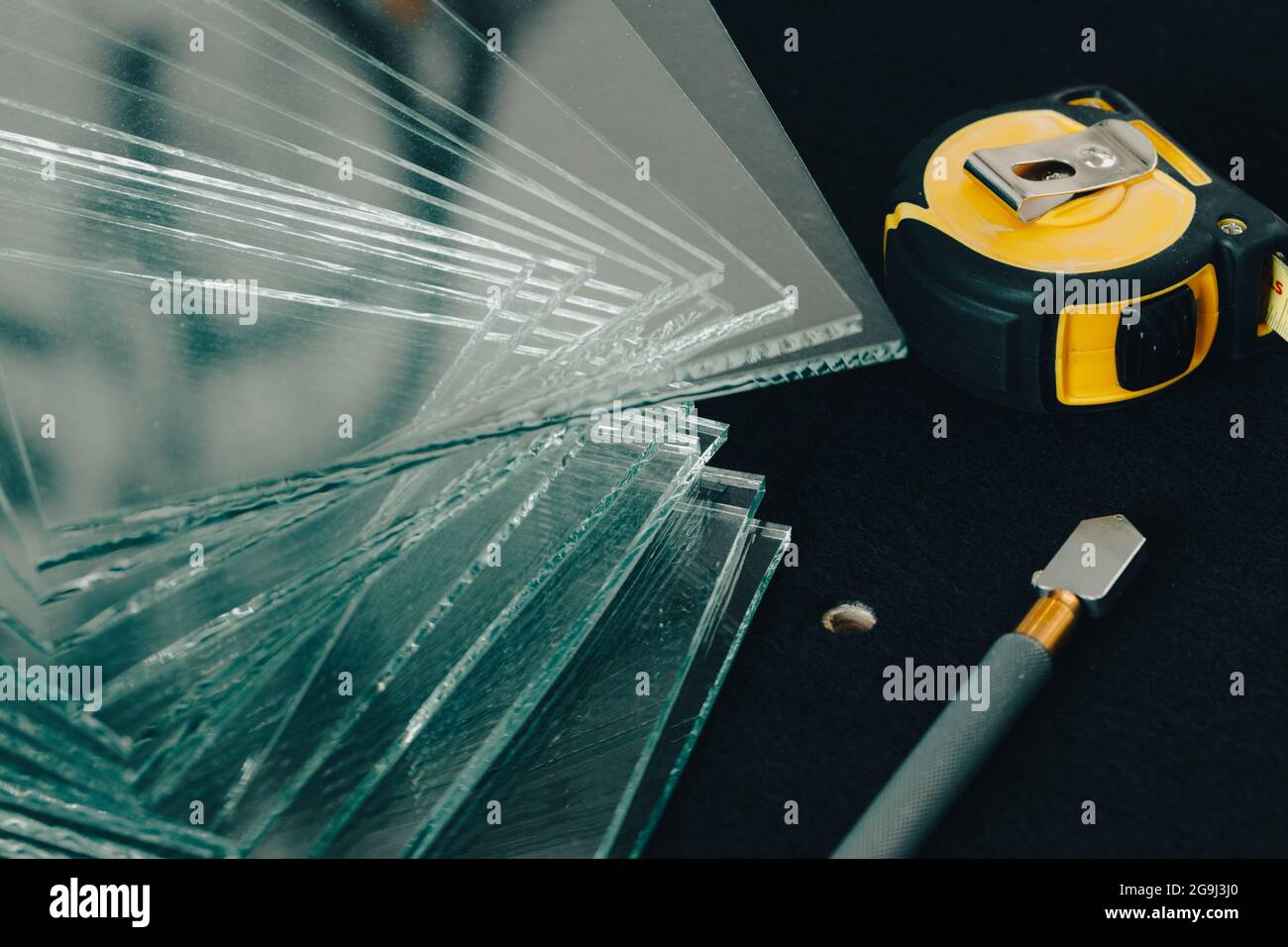 a pile of cut glass pieces and glazier tools Stock Photo - Alamy