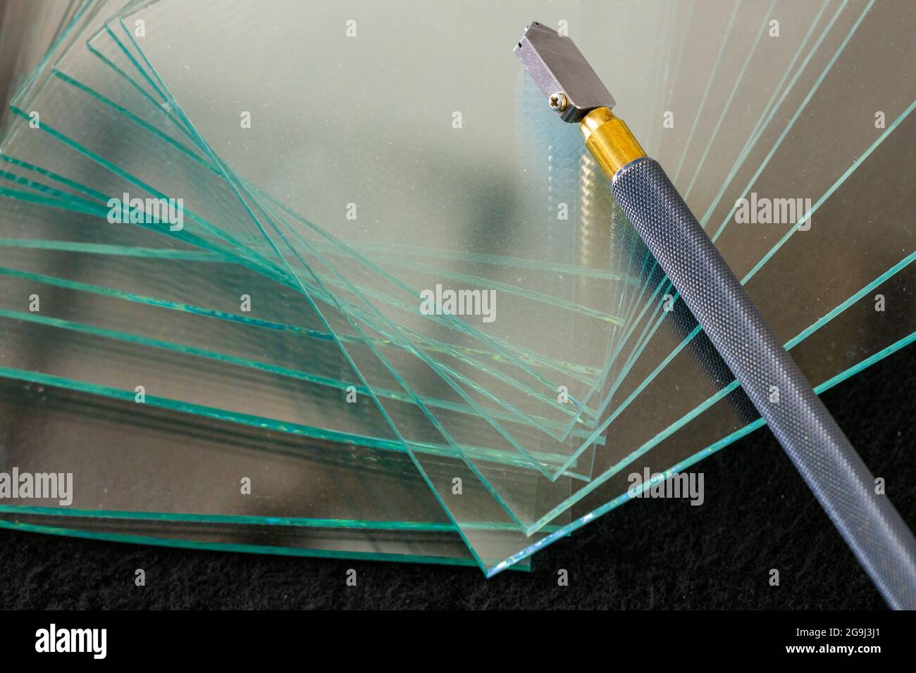 a pile of cut glass pieces and glazier tools Stock Photo - Alamy