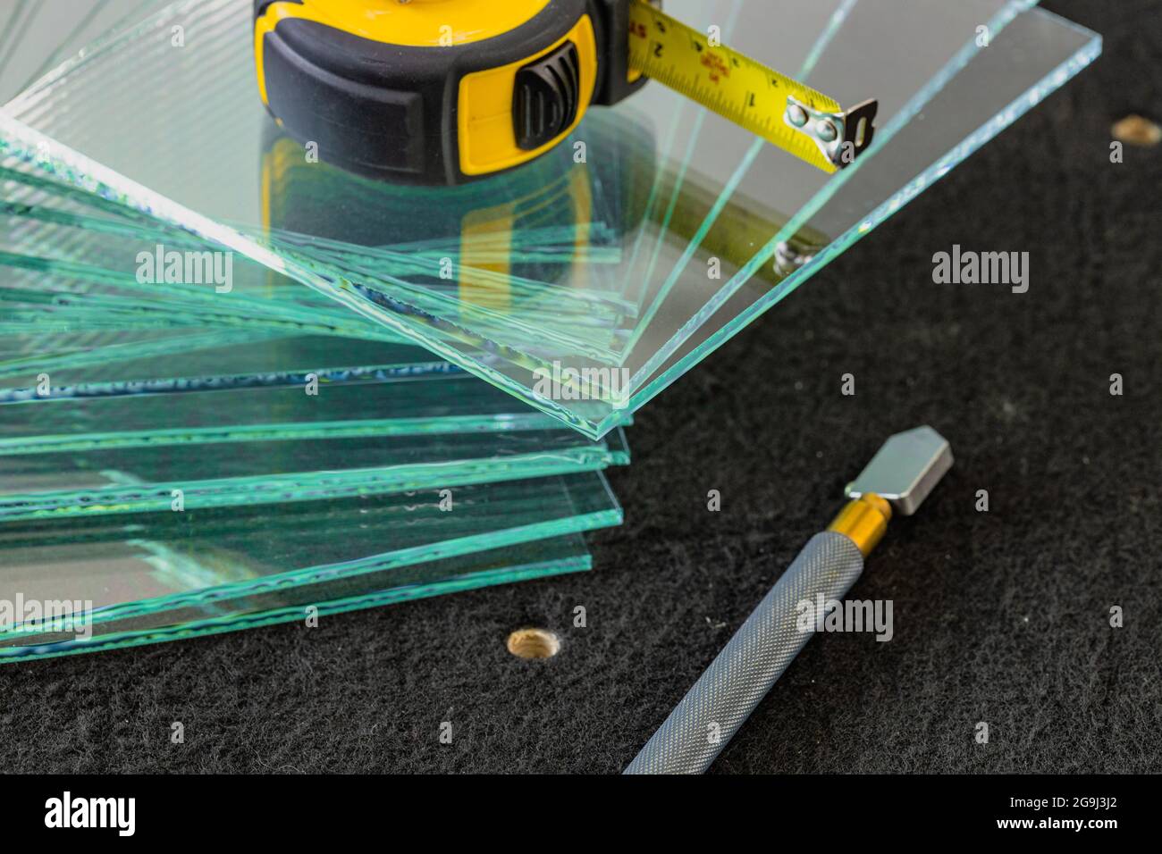 a pile of cut glass pieces and glazier tools Stock Photo - Alamy