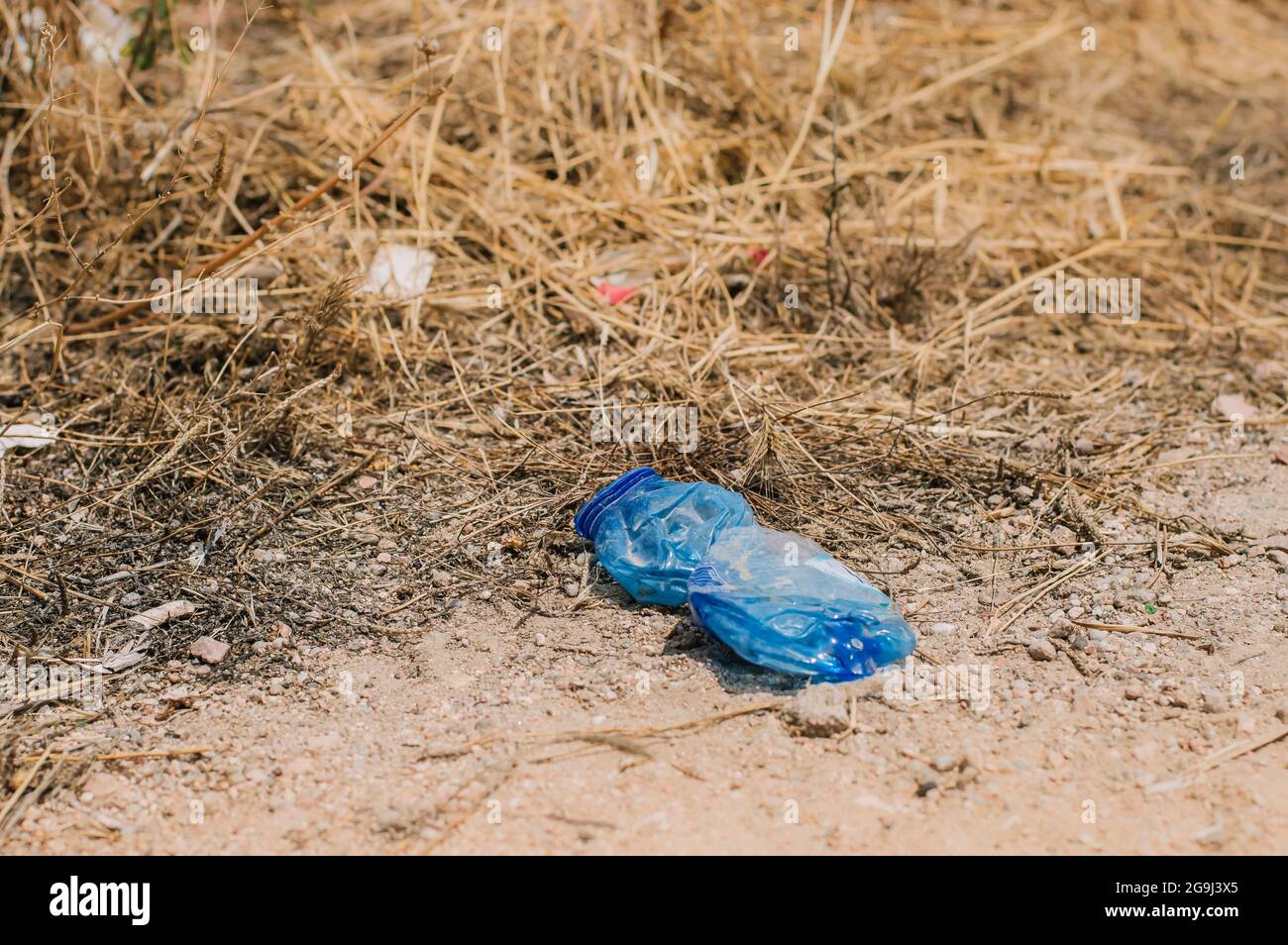 crumpled plastic bottle on the field,environmental pollution Stock ...