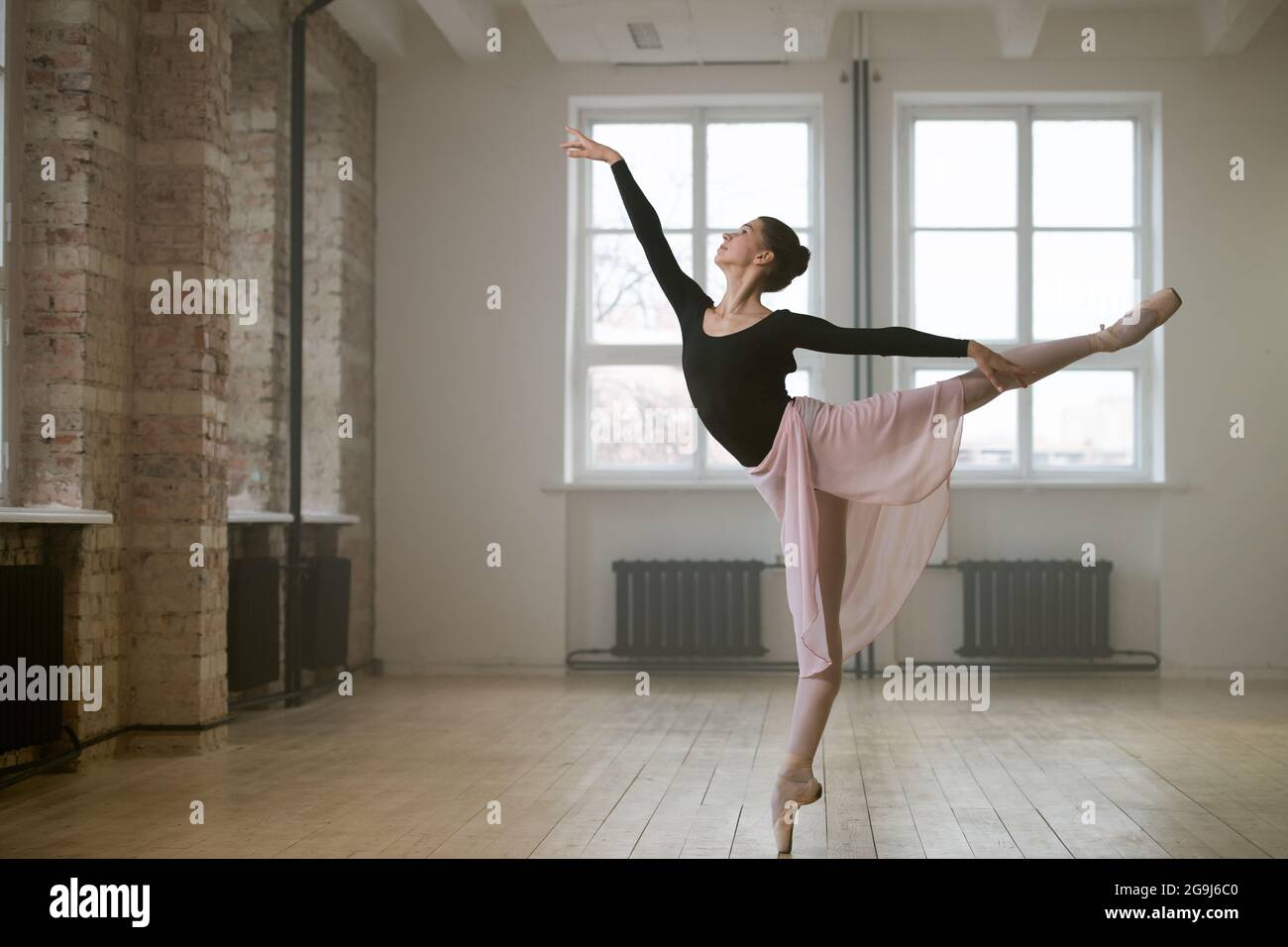 Young woman in tutu dress dancing ballet during training in dance ...