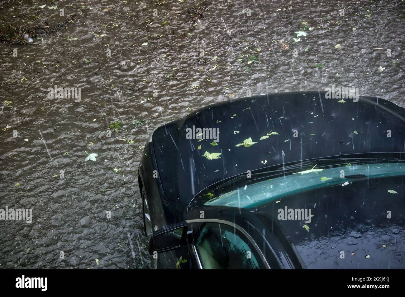 Top view shows front of a black car drained and stuck in a heavy rain ...