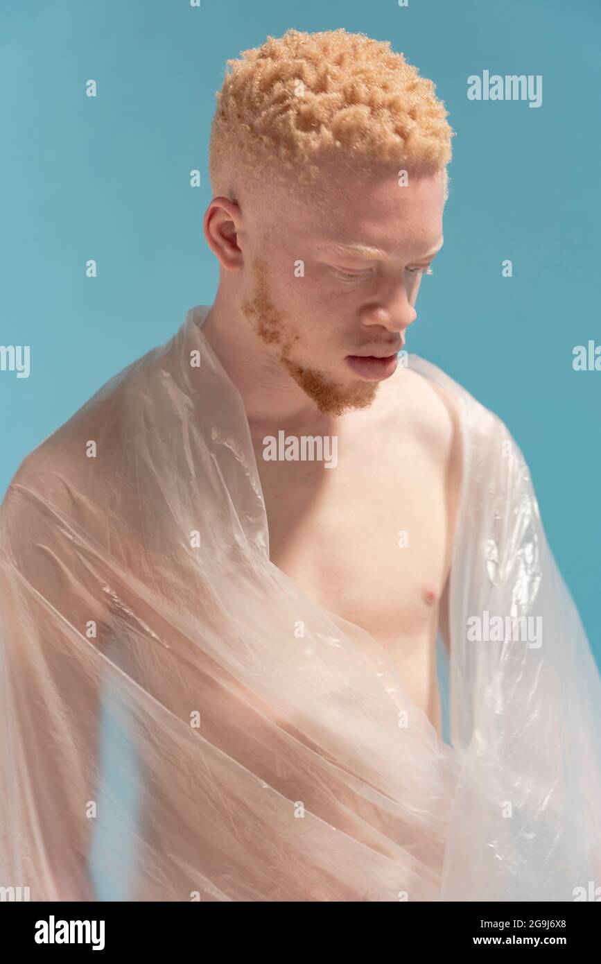 Studio portrait of shirtless albino man wrapped in plastic sheet Stock ...