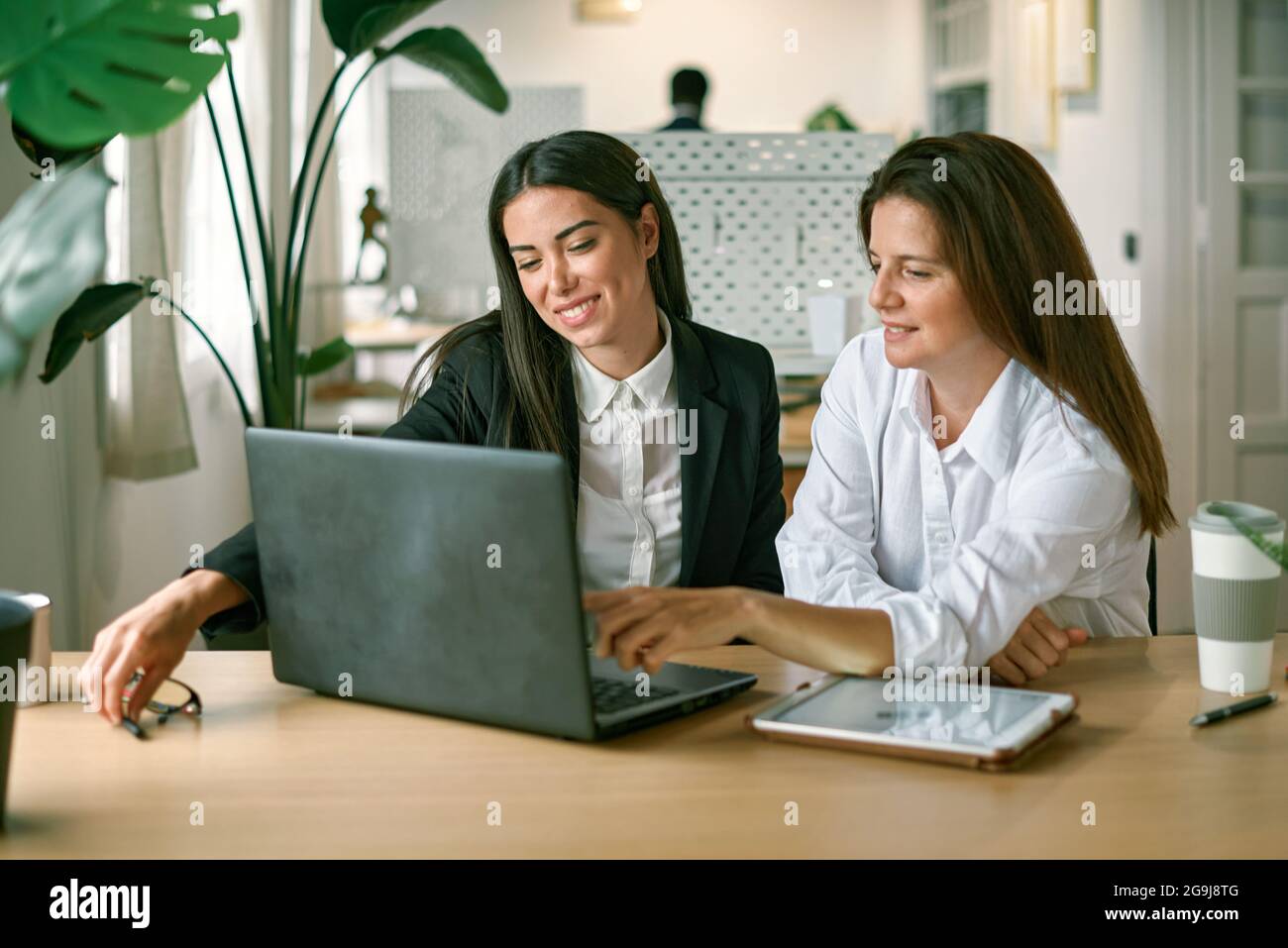 Female employees working on project together Stock Photo - Alamy