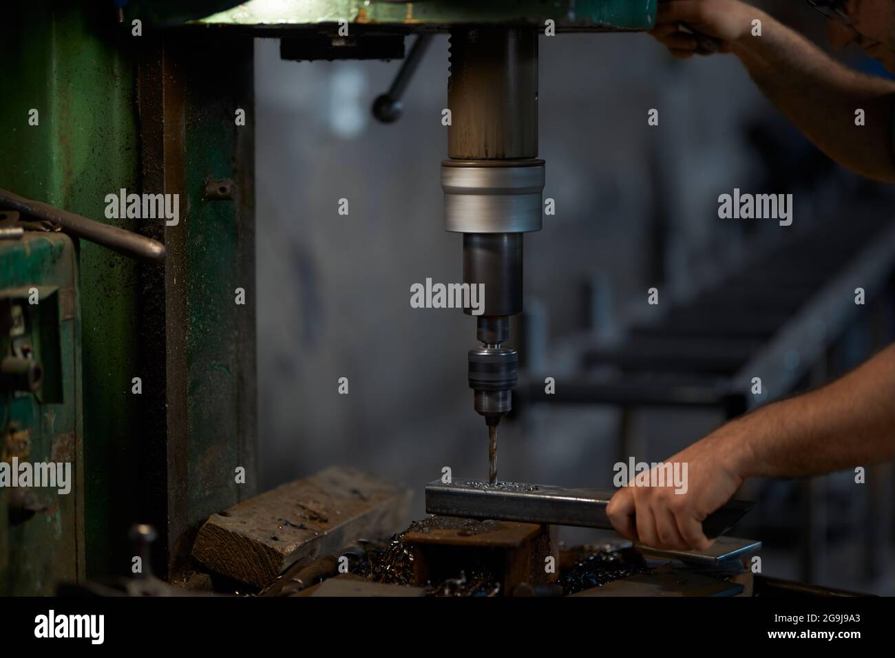 Close up of strong male hands using industrial drill press for making ...