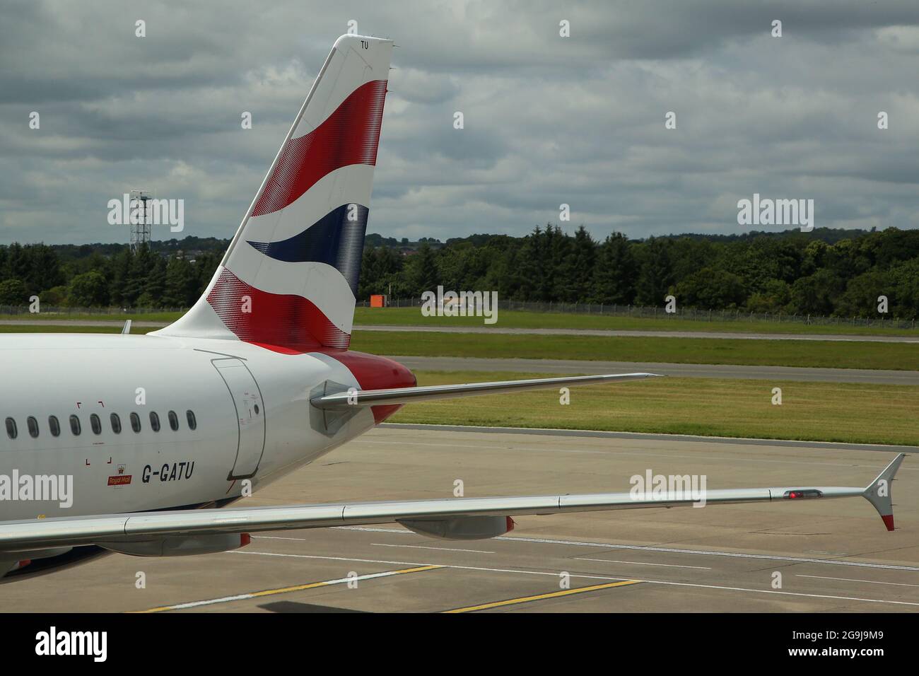 Tail and wing of British Airways aircraft waiting at a gate at ...