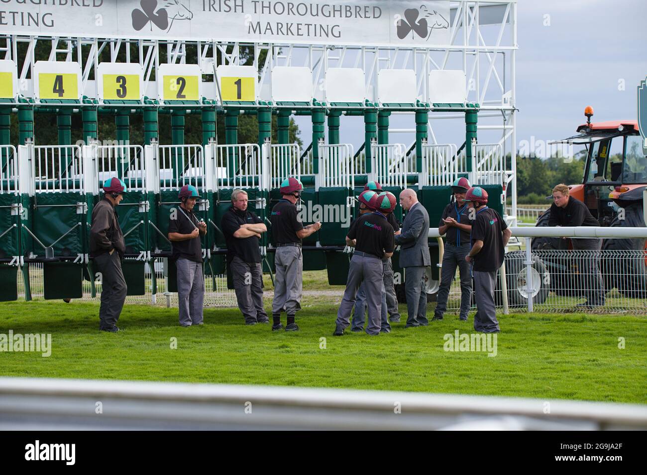 Racecourse staff waiting at the starting gate for the jockeys and ...
