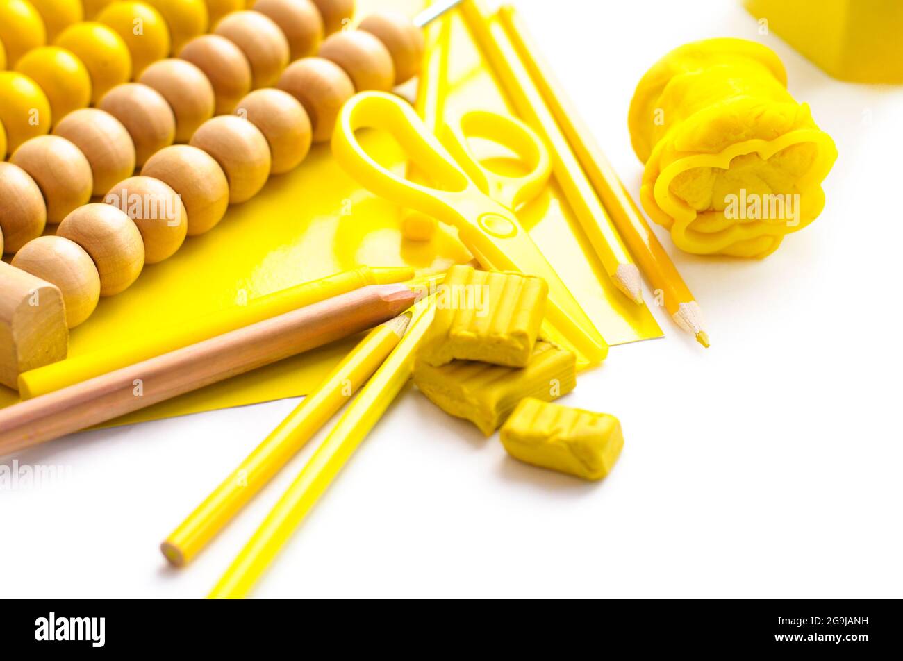 Background with yellow plasticine, colored pencils and other tools for ...